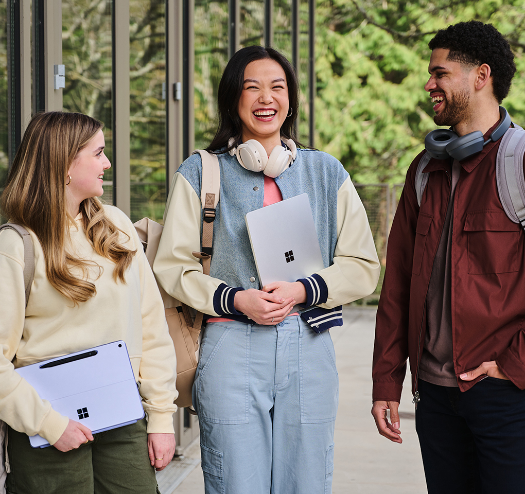 Three students chatting outside of a building.